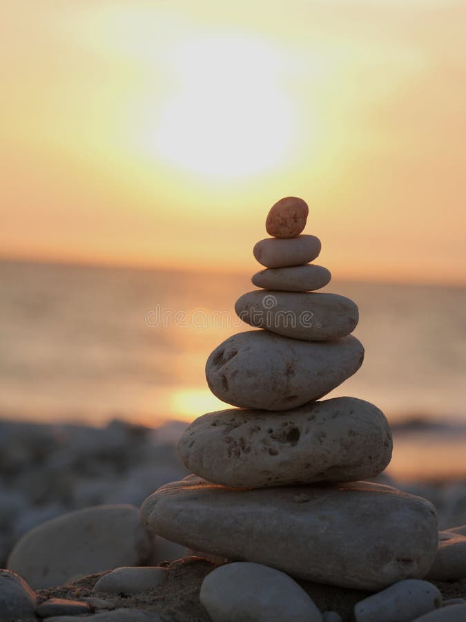 Stack of Pebbles Facing the Sunset Over the Ocean Stock Photo - Image ...