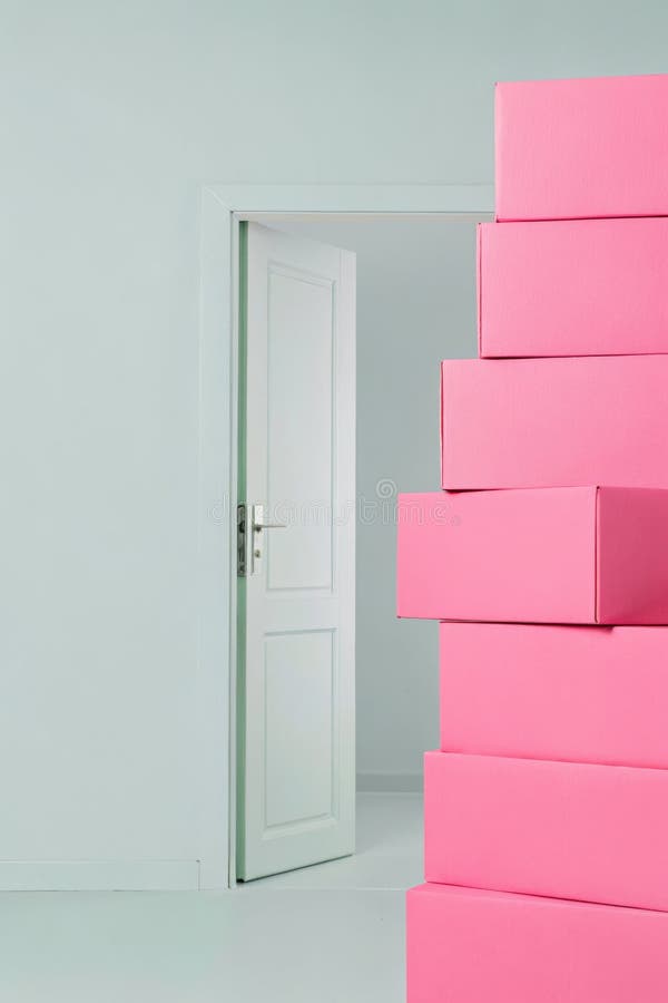 Stack of Pink Boxes beside an Open White Door Against Minimalist Pastel ...