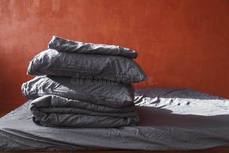 A Stack of Plain Pillows, Blankets on the Bed. Gray Linens on Red Wall ...