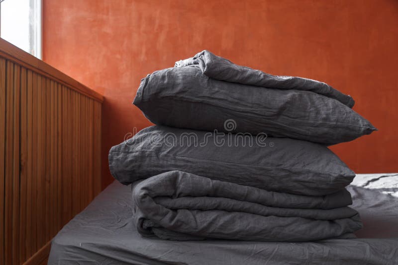 A Stack of Plain Pillows, Blankets on the Bed. Gray Linens on Red Wall ...
