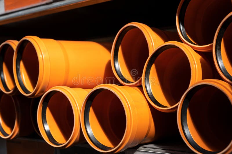 Stack of PVC U Canalization Pipes on a Store. Brown Plastic Pipes ...