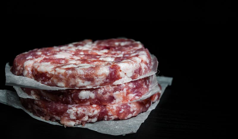 Stack of Raw Beef Meat Burger Steak Cutlets Beefsteack on Paper on Dark ...