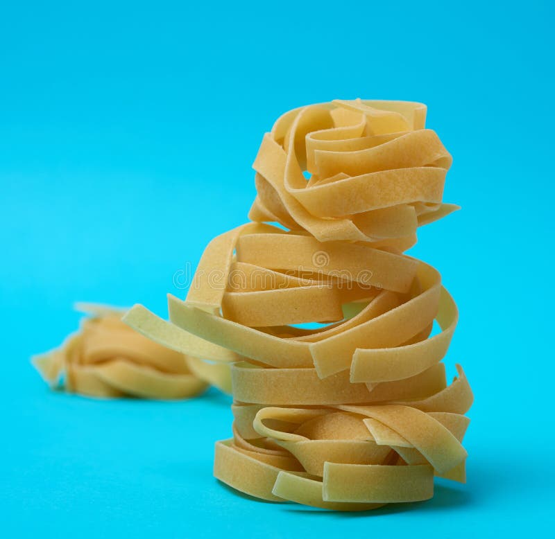 Stack of Raw Fettuccine Pasta on a Blue Paper Stock Photo - Image of ...