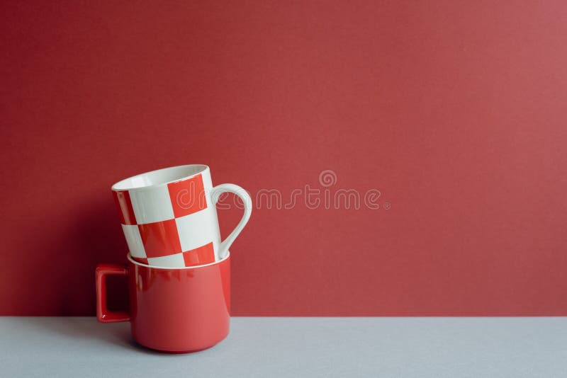 Stack of Red Mug Cups on Gray Table. Red Wall Background Stock Image ...