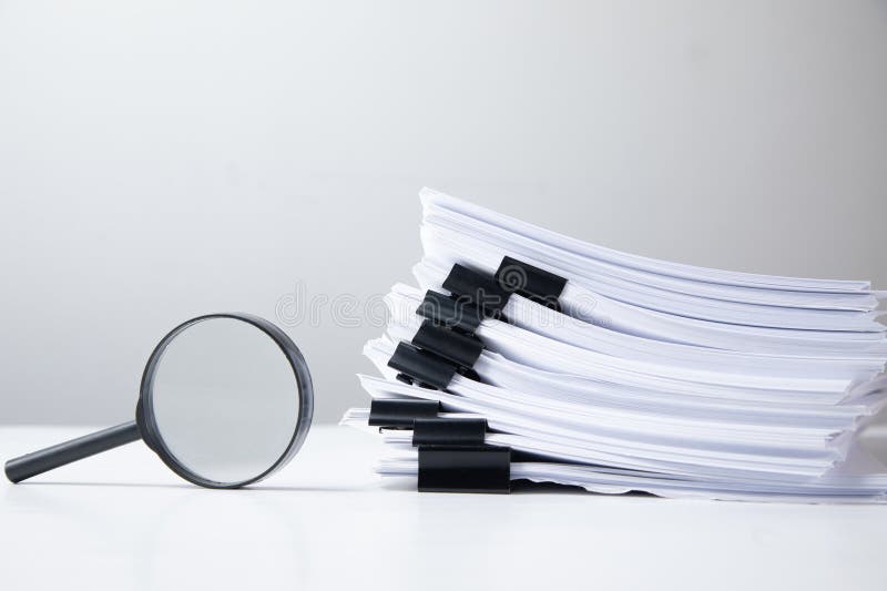 Stack of Report Paper Documents with Magnifying Glass Stock Photo ...