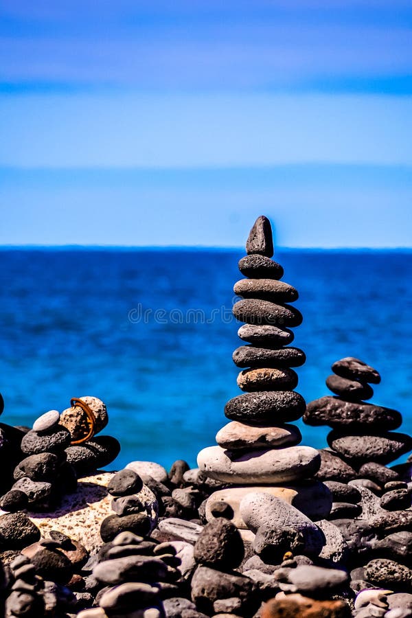A Stack of Rocks is on the Beach Next To the Ocean Stock Image - Image ...