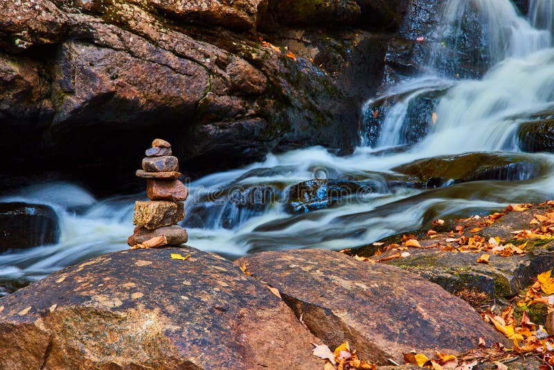 Stack of Rocks Cairn on Edge of Cascading River with Fall Leaves Stock ...