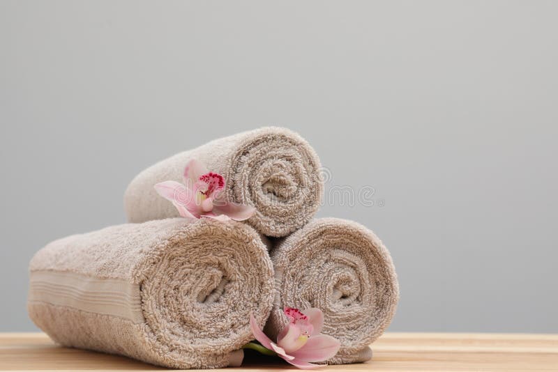 Stack of Rolled Towels and Flowers on Table Stock Image - Image of ...