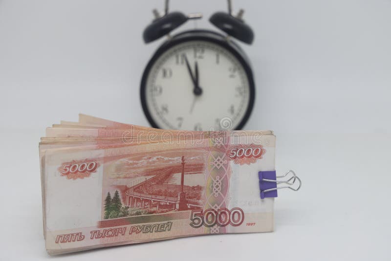 A Stack of Russian Banknotes on the Background of an Alarm Clock, Time ...