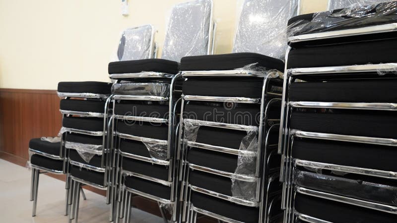 A Stack of Several Chairs Vertically Leaning Against a Wall Stock Image ...