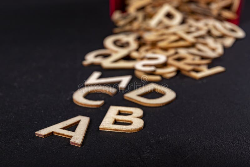 A Stack of Small Wooden Letters on a Dark Table. Letters Outlines for ...
