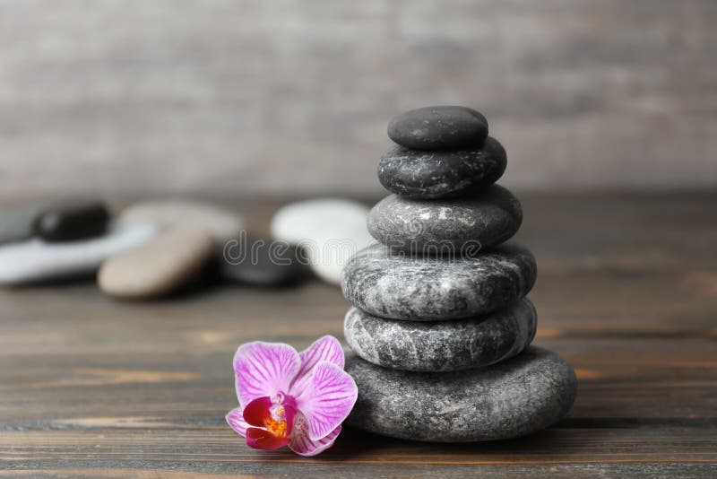 Stack of Spa Stones and Beautiful Flower on Wooden Table Stock Photo ...