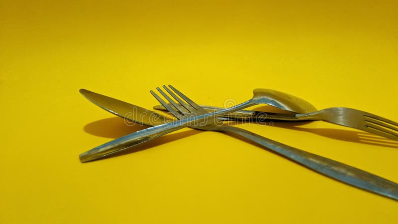 Stack of Spoons and Forks on Yellow Background. Stock Photo - Image of ...