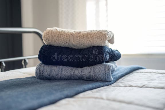 Stack of Sweaters Folded on the Bed Stock Photo - Image of soft ...