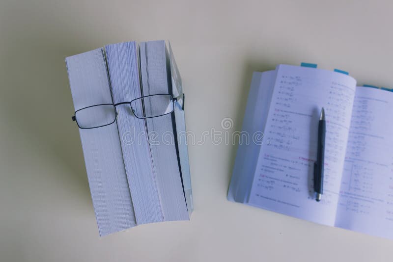 A Stack of Thick New Books and Black Glasses Depict a Person`s Face ...