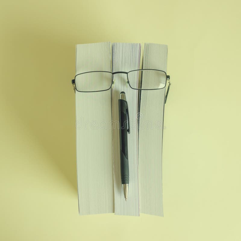 A Stack of Thick New Books and Black Glasses Depict a Person`s Face ...