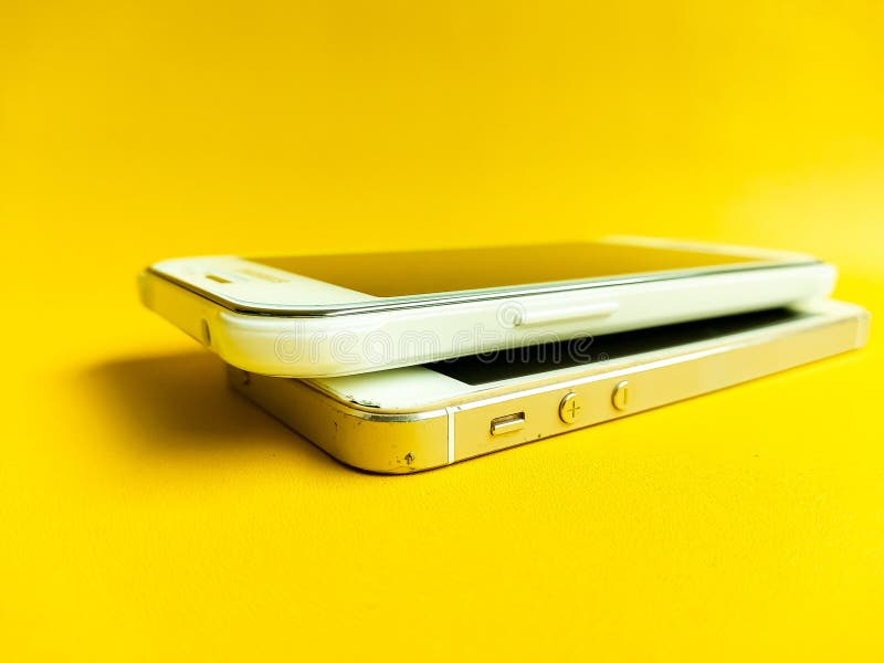 Stack of Two Mobile Phones on Yellow Background Stock Photo - Image of ...