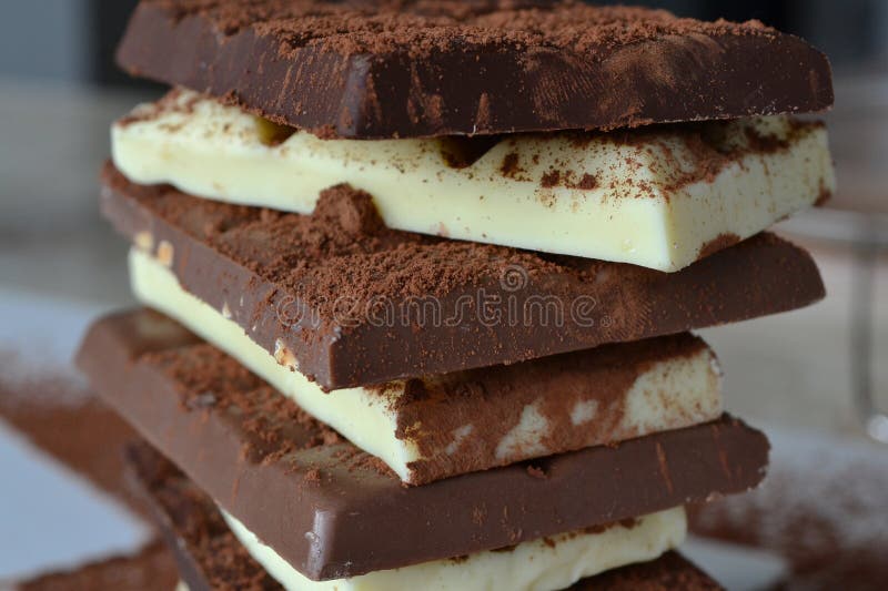 A Stack of Various Chocolates in Cocoa Powder Lies on a White Table ...