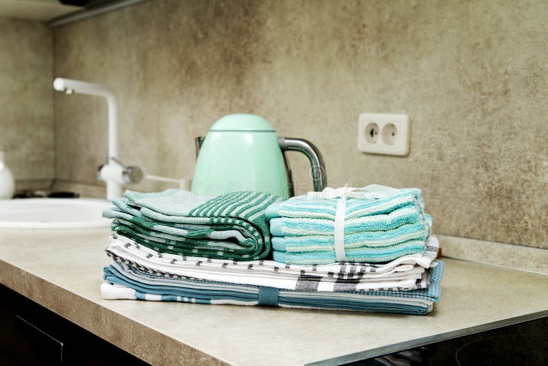 Stack of Various Kitchen Towels and a Turquoise Electric Kettle in a ...