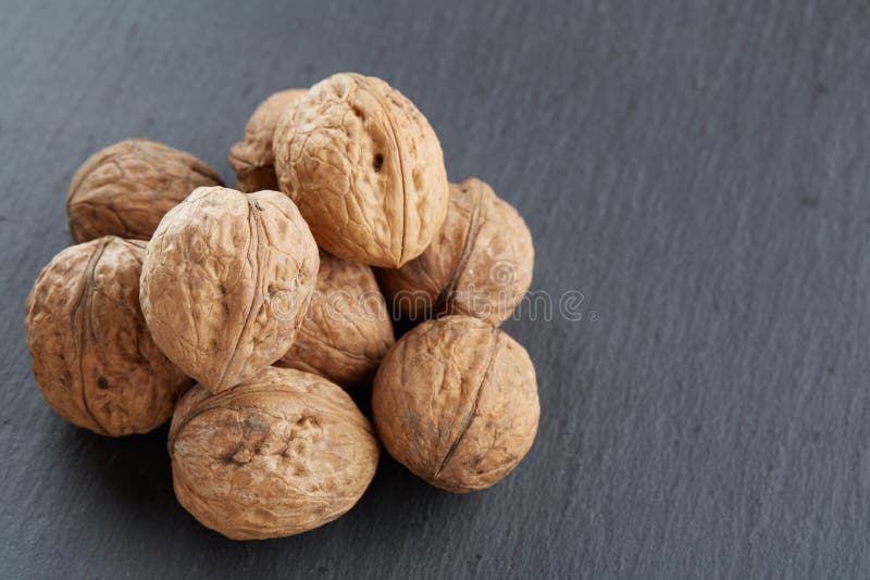 A Stack of Walnuts Piled Together and on Dark Background, Shallow Depth ...
