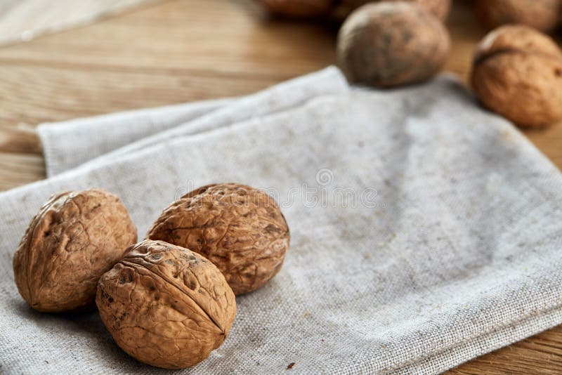 A Stack of Walnuts Piled Together and on Rustic Wooden Background ...