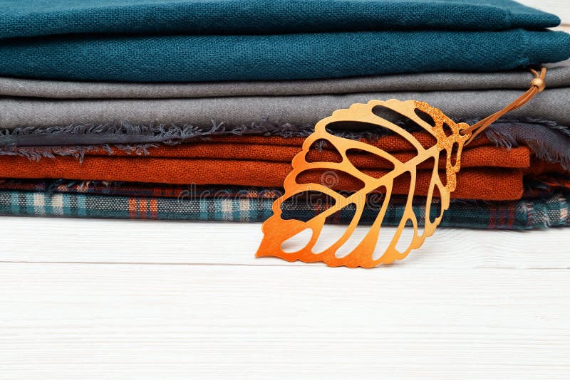 Stack of Warm Woolen Scarf Lying on Wooden Table and Decorated Autumn ...