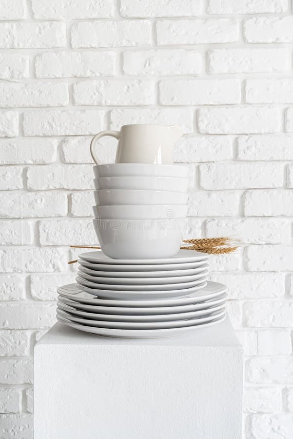 Stack of White Ceramic Dishes and Tableware on White Brick Wall ...