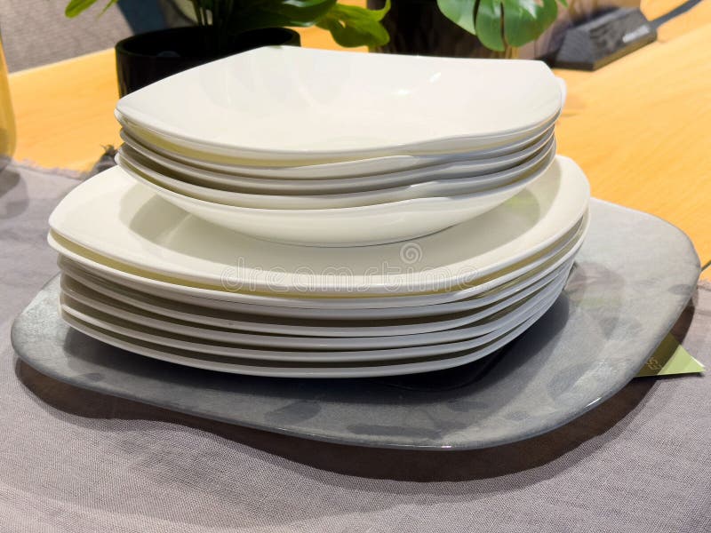 Stack of White Ceramic Plates on Wooden Table with Gray Placemat ...