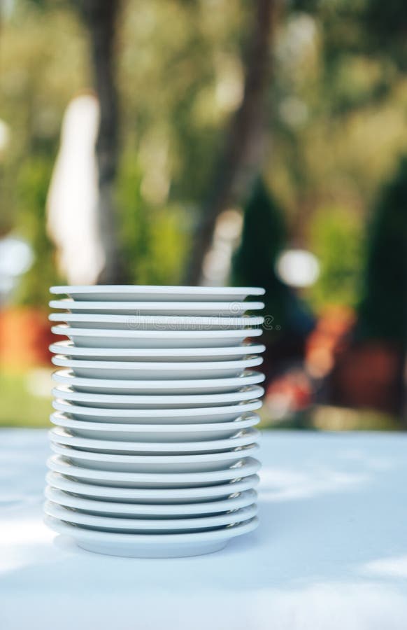 Stack of White Ceramics Plate Outdoor. Stacked White Dishes on the ...