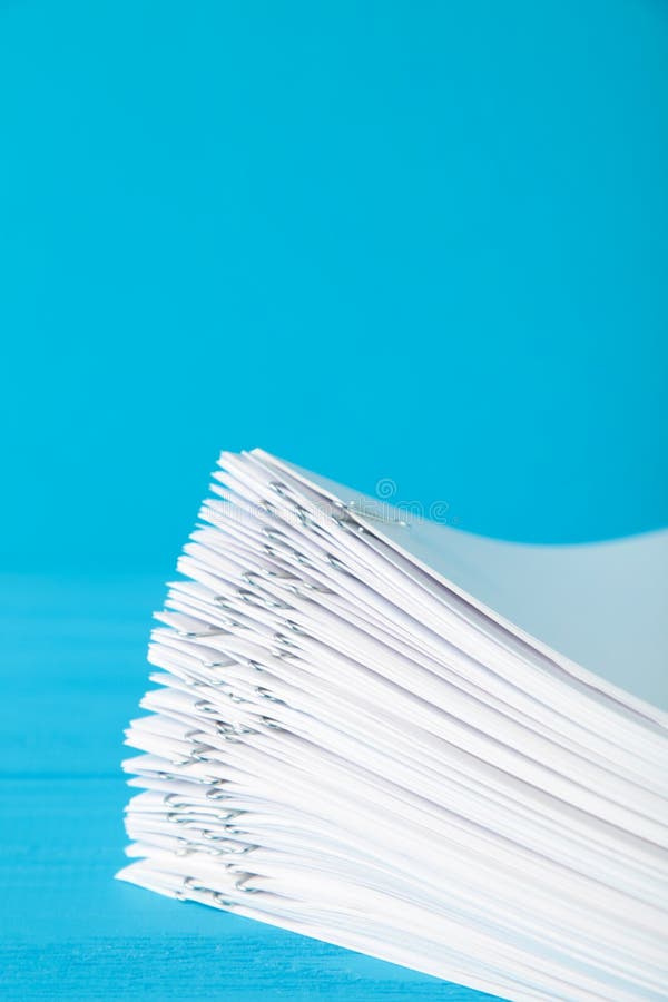 Stack of White Paper with Clips on Blue Background. Vertical Foto Stock ...