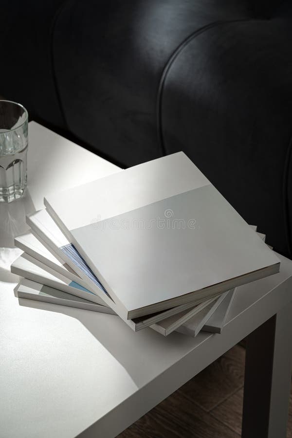 Stack of White Paperbacks and Glass of Water on White Table Stock Image ...