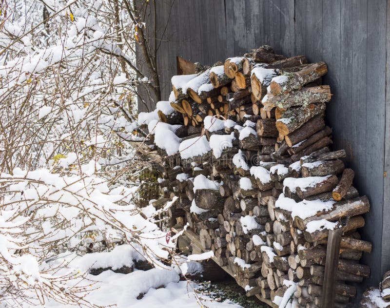 Snow Covers a Stack of Wood, Which is Stacked Against a Building. Stock ...