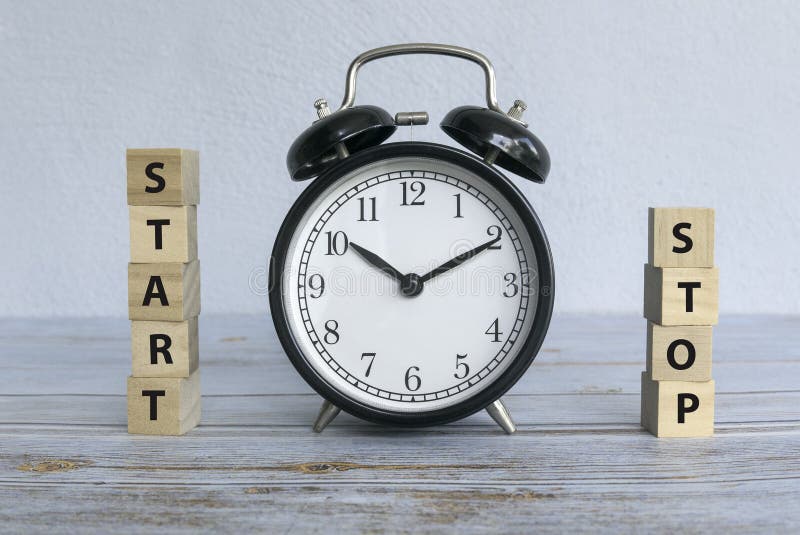 A Stack of Wooden Cube of Word START and STOP with Vintage Alarm Clock ...