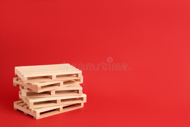 Stack of Wooden Pallets on Red Background, Space for Text Stock Photo ...