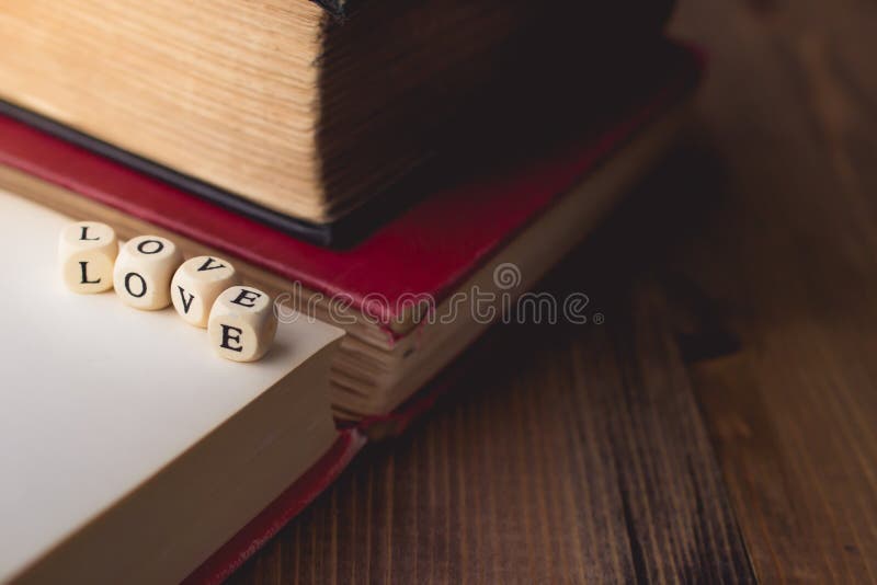 Stack of Word Love and Old Book on Wooden with Copy Space Stock Photo ...