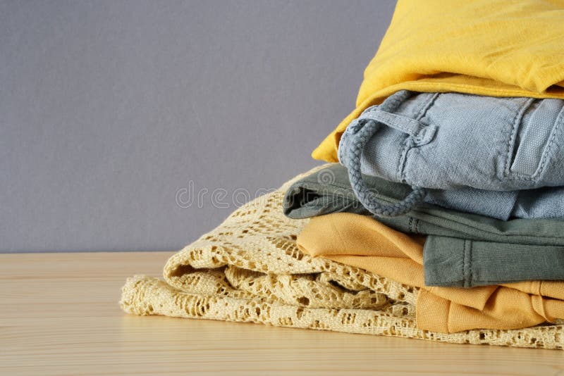 Stack of Clothes in Yellow Green Colors in Woman S Hands on White ...