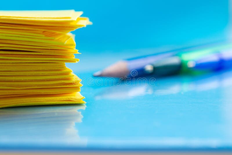 A Stack of Yellow Paper and a Pencil on a Blue Table Close-up. Stock ...