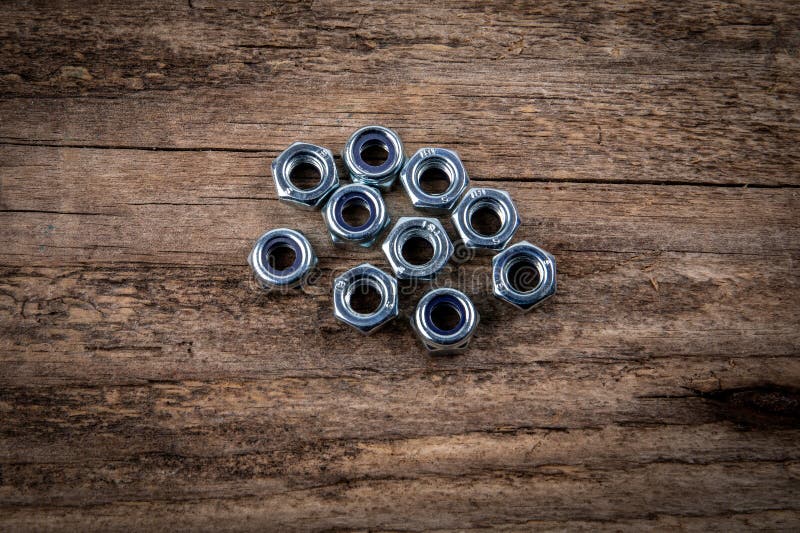 Stack of Zinc Plated Self Locking Hexagon Nuts on a Dark Wood Texture ...