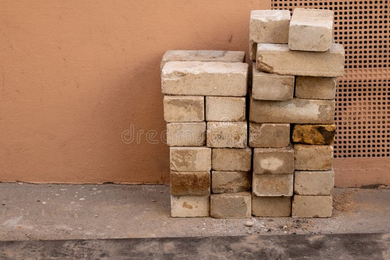 Stacked Bricks in Front of a House Wall Stock Photo - Image of ...