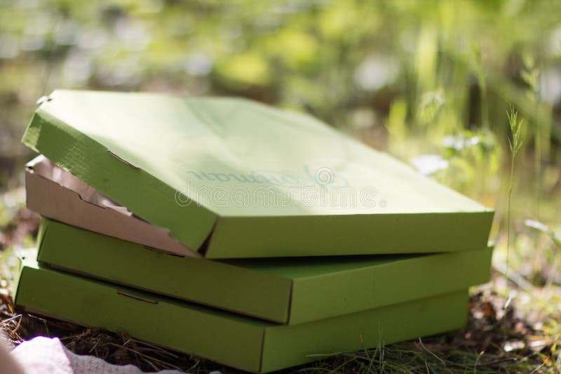 Stacked, Light-green Pizza Boxes Sit on the Ground, Partially Covered ...