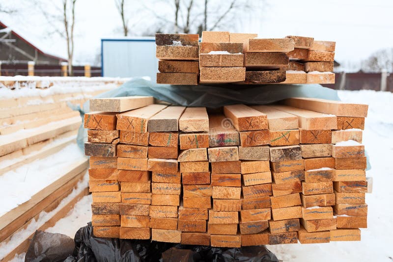 Stacked Lumber at Construction Site. Winter Construction of Timber ...