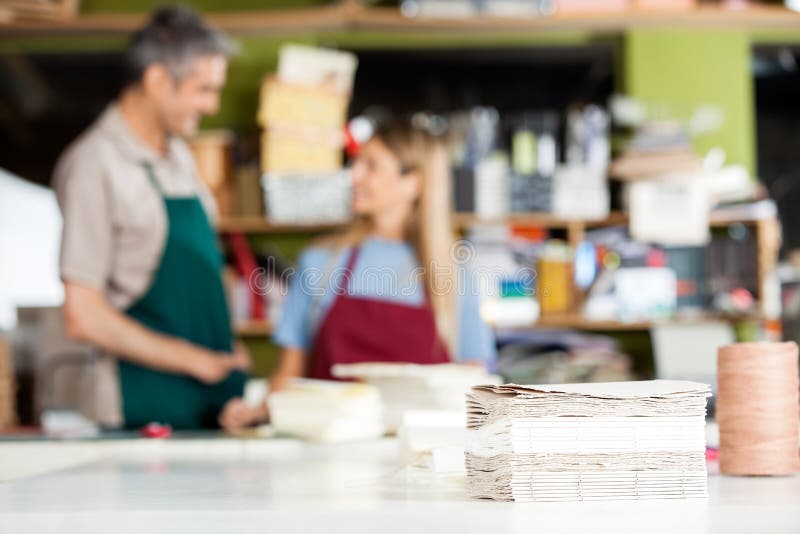 Stacked Papers on Table with Workers in Background Stock Photo - Image ...