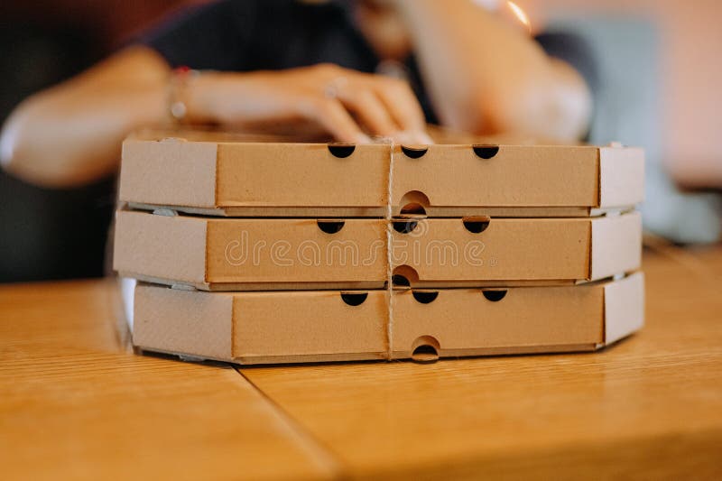 Stacked Pizza Boxes Ready for Delivery in a Cozy Restaurant Setting ...