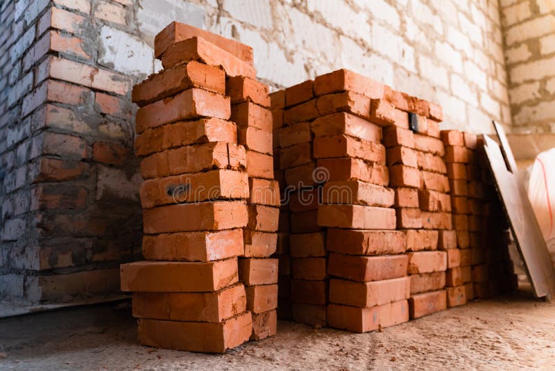 Stacked Red Bricks Construction Site Against the Background of a Wall ...