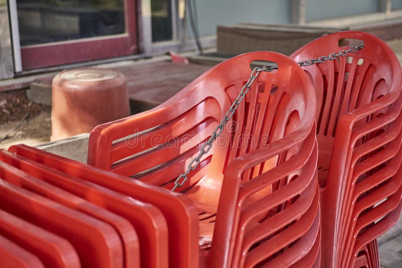 Stacked Red Plastic Chairs Secured with a Chain Stock Photo - Image of ...