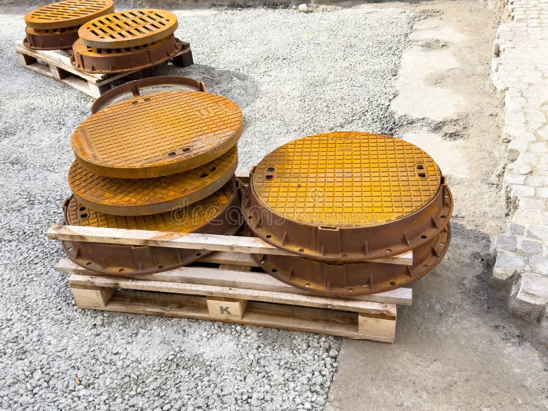 Stacked Rusty Manhole Covers on Wooden Pallets at Construction Site ...