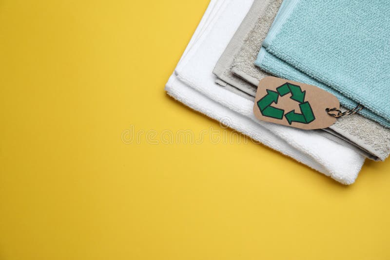 Stacked Towels with Recycling Label on Yellow Background, Top View ...