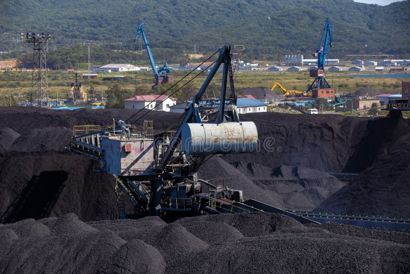 Stacker-reclaimer during Loading and Unloading of Coal. Coal Heaps at a ...