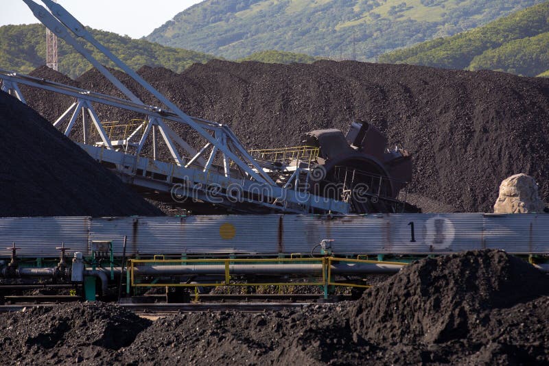 Stacker-reclaimer during Loading and Unloading of Coal. Coal Heaps at a ...