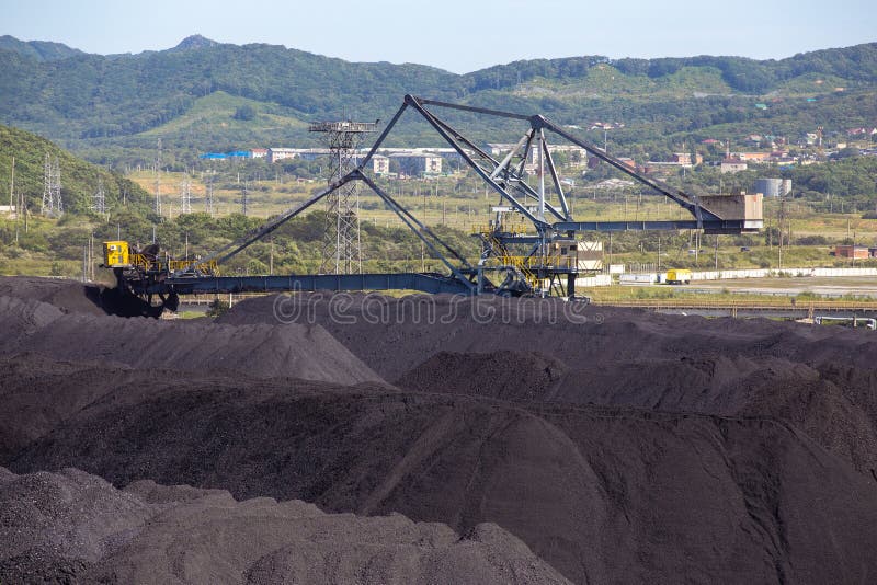 Stacker-reclaimer during Loading and Unloading of Coal. Coal Heaps at a ...